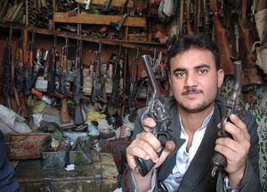 [Yemen] An arms merchant displays two old British revolvers, while ...