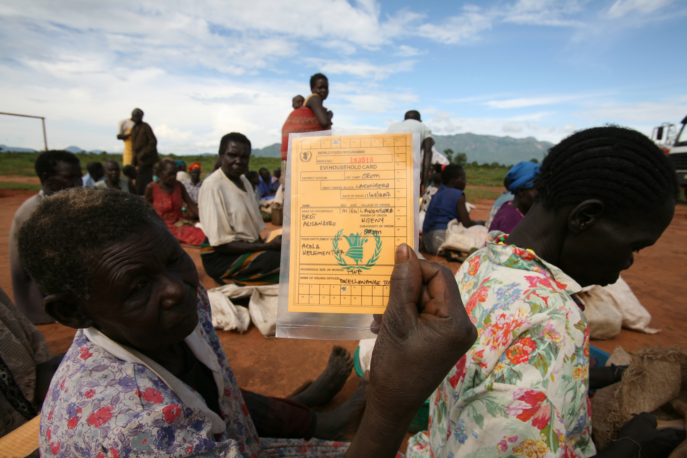 An old woman showing her WFP card in order to get rations at Oromi IDP ...