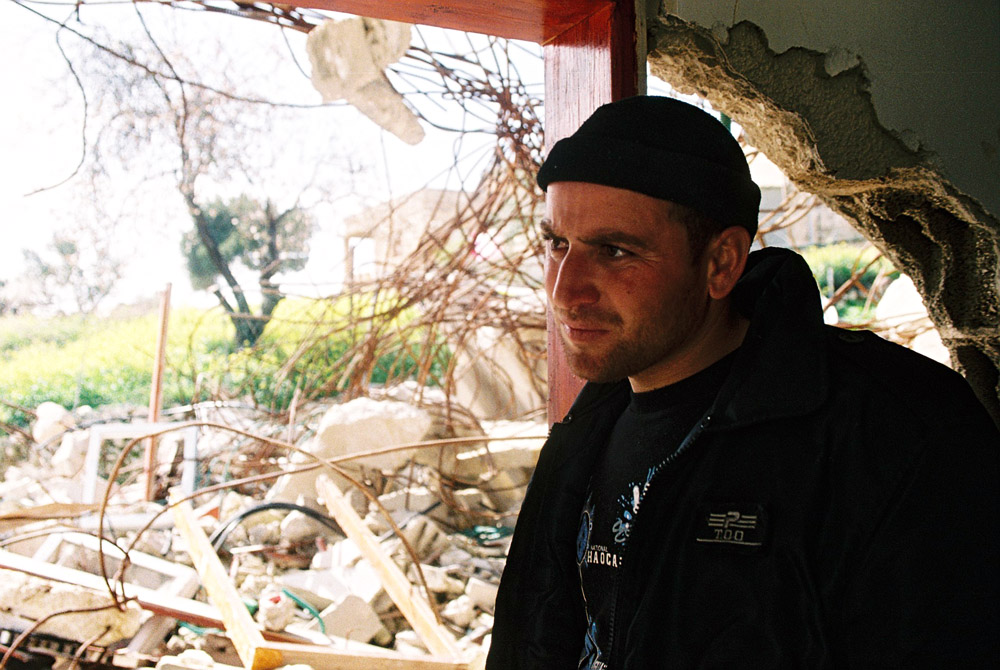 Nidal stands inside the remains of his home, destroyed in 2006 by ...