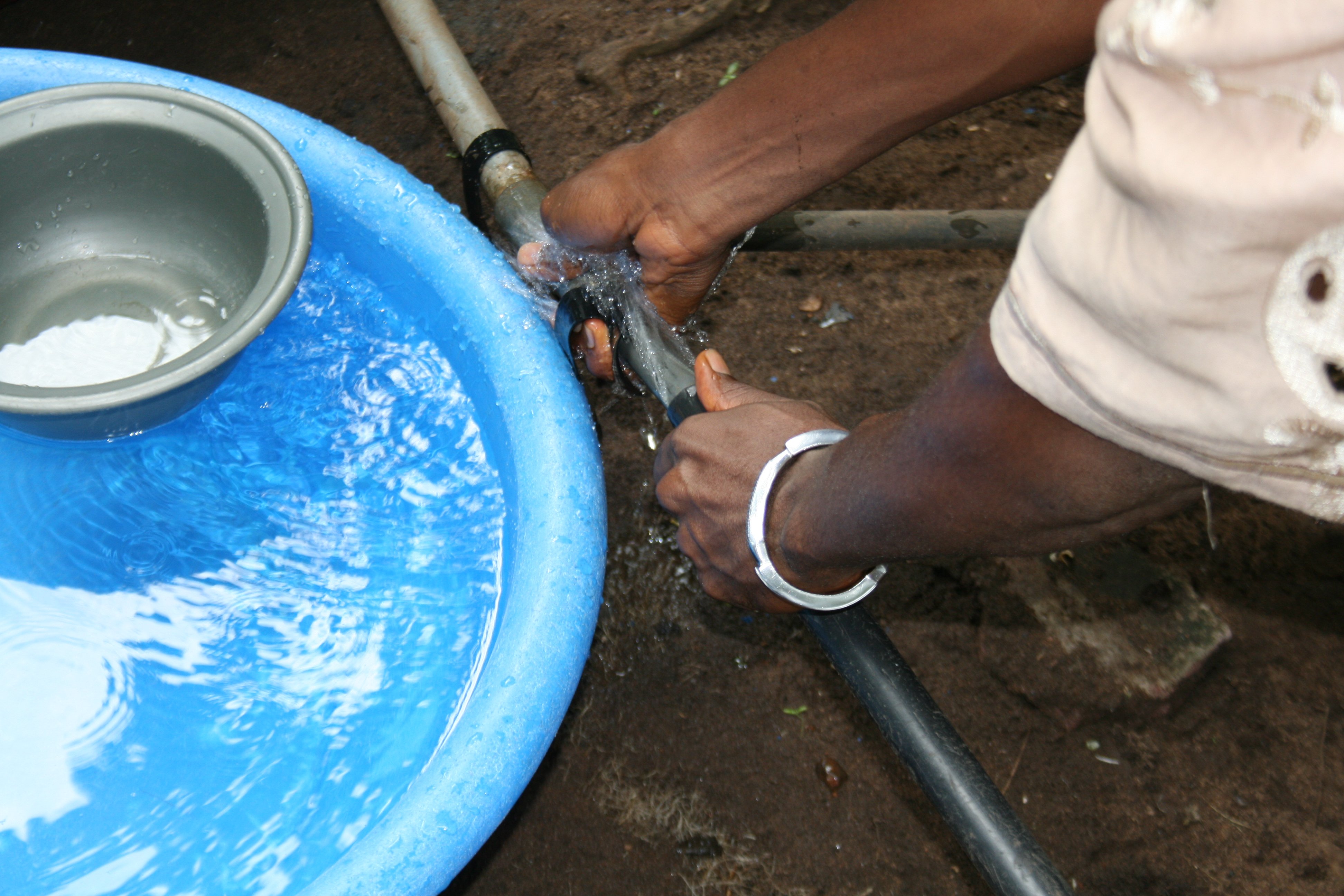 Residents of the Guinea capital, Conakry, try to capture water on the ...