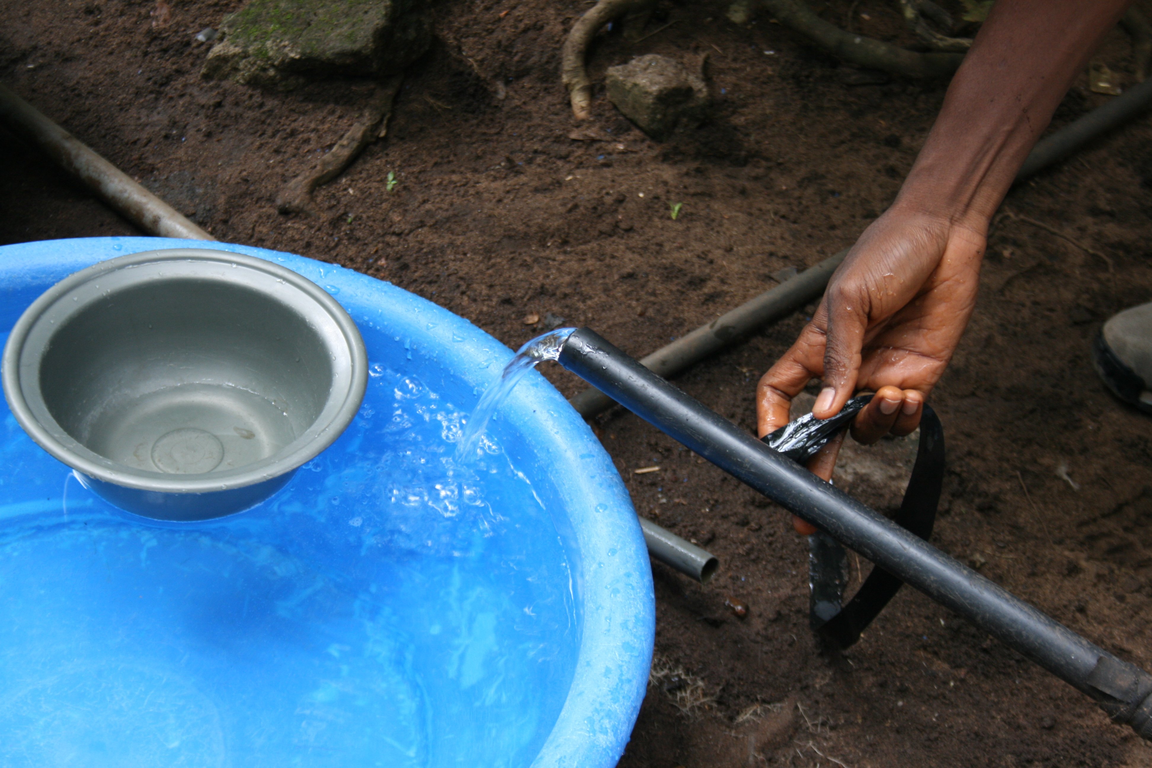 Residents of the Guinea capital, Conakry, try to capture water on the ...