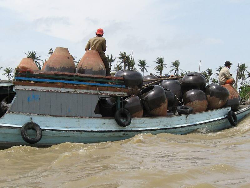 A boat carrys large ceremic pots more remote areas of cyclone-affected ...