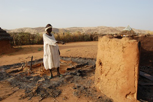 Awad Al-Karim stands amid the ruins of his home that was burnt during a ...