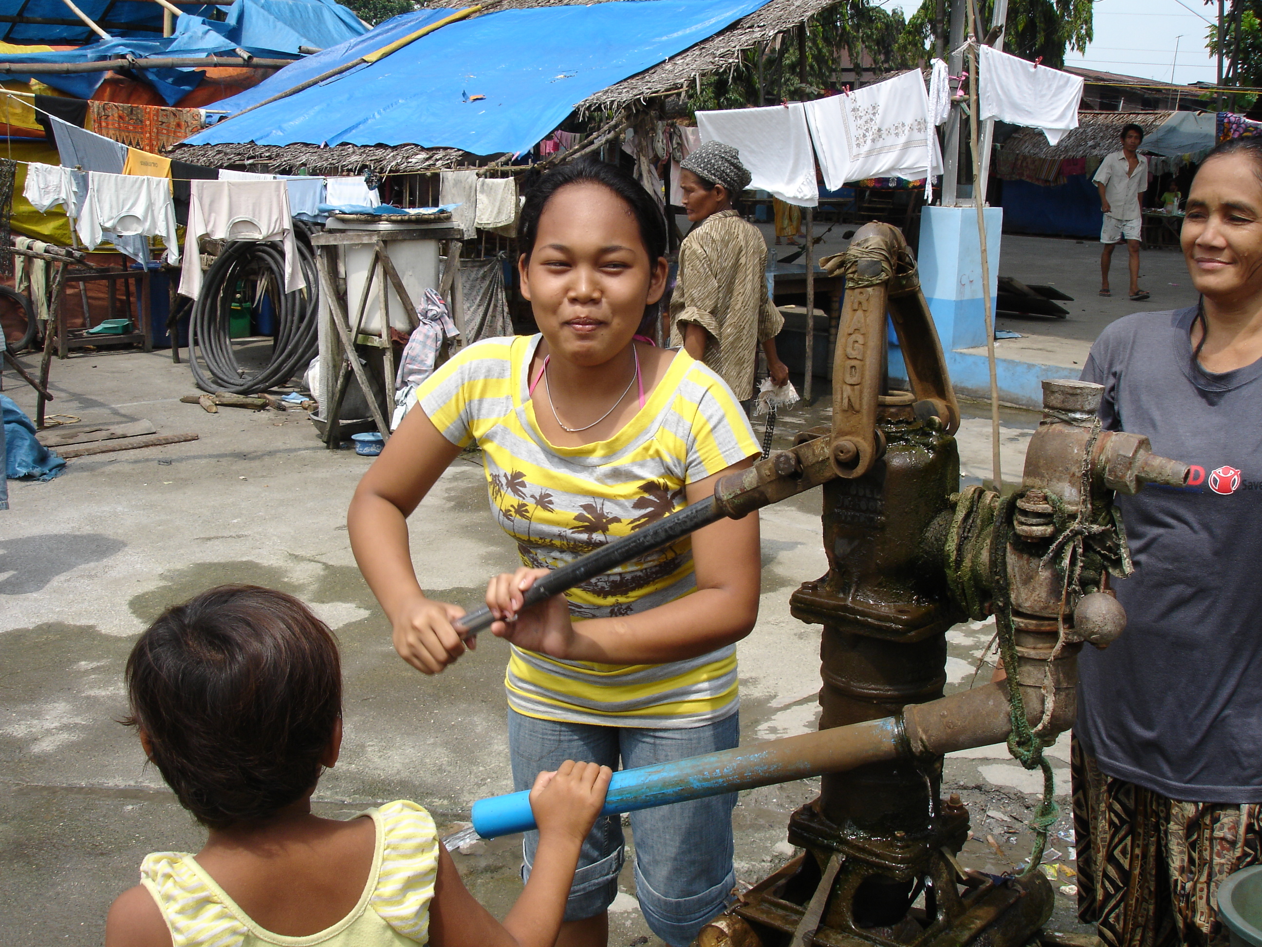 A woman pumps water at the Datu Piang Plaza evacuation centre in Datu ...