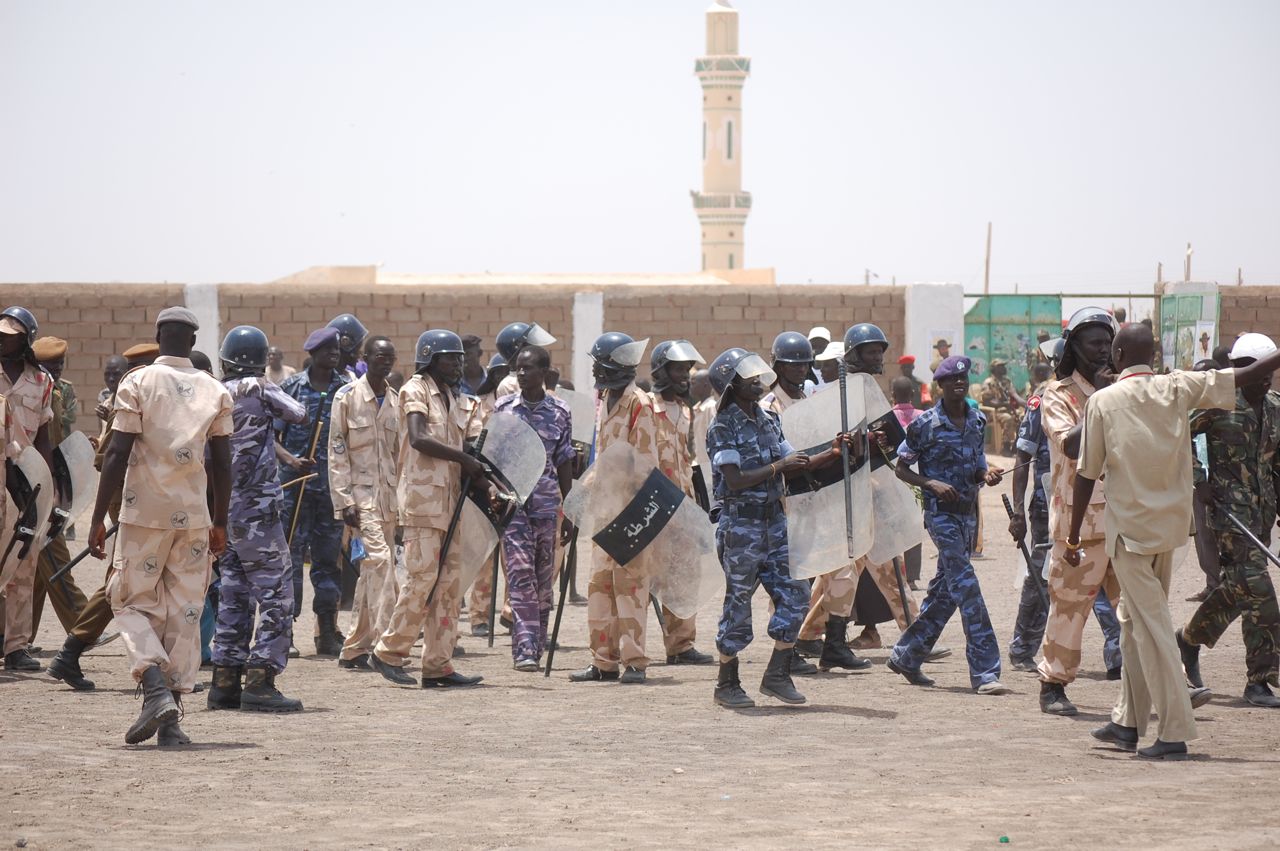 Southern Sudan security forces gather near a political rally in Bentiu ...
