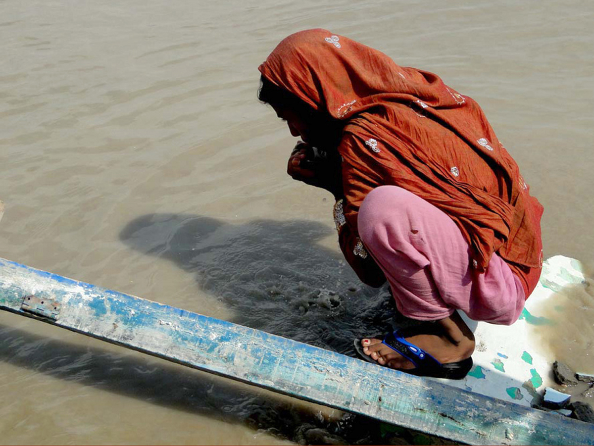 A woman in Kalabagh, Pakistan drinks dirty flood water. Waterborne ...