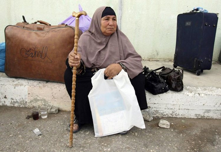 An elderly woman waits at the Rafah border crossing on the border ...