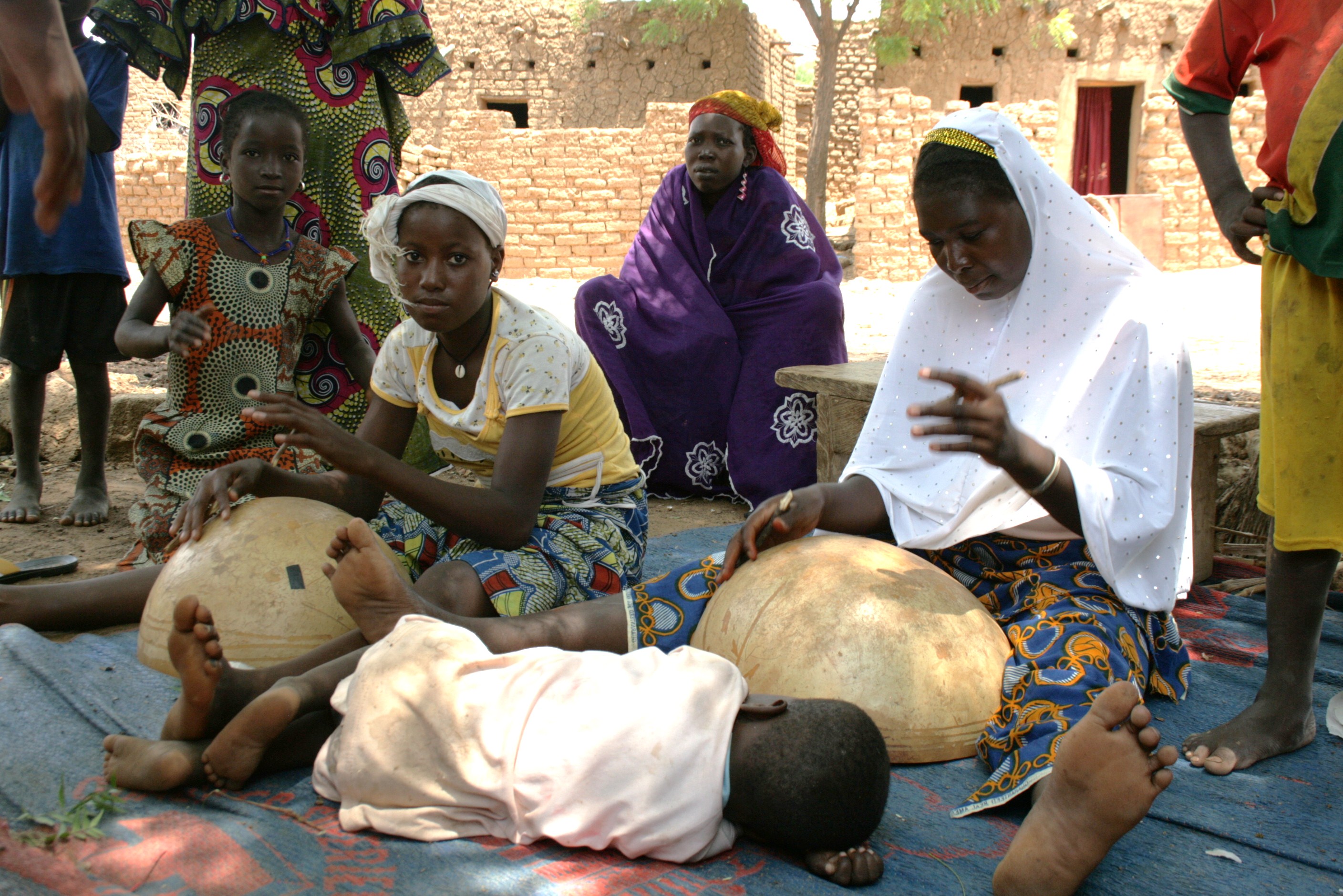 Young women play instruments made from calabash during a wedding ...