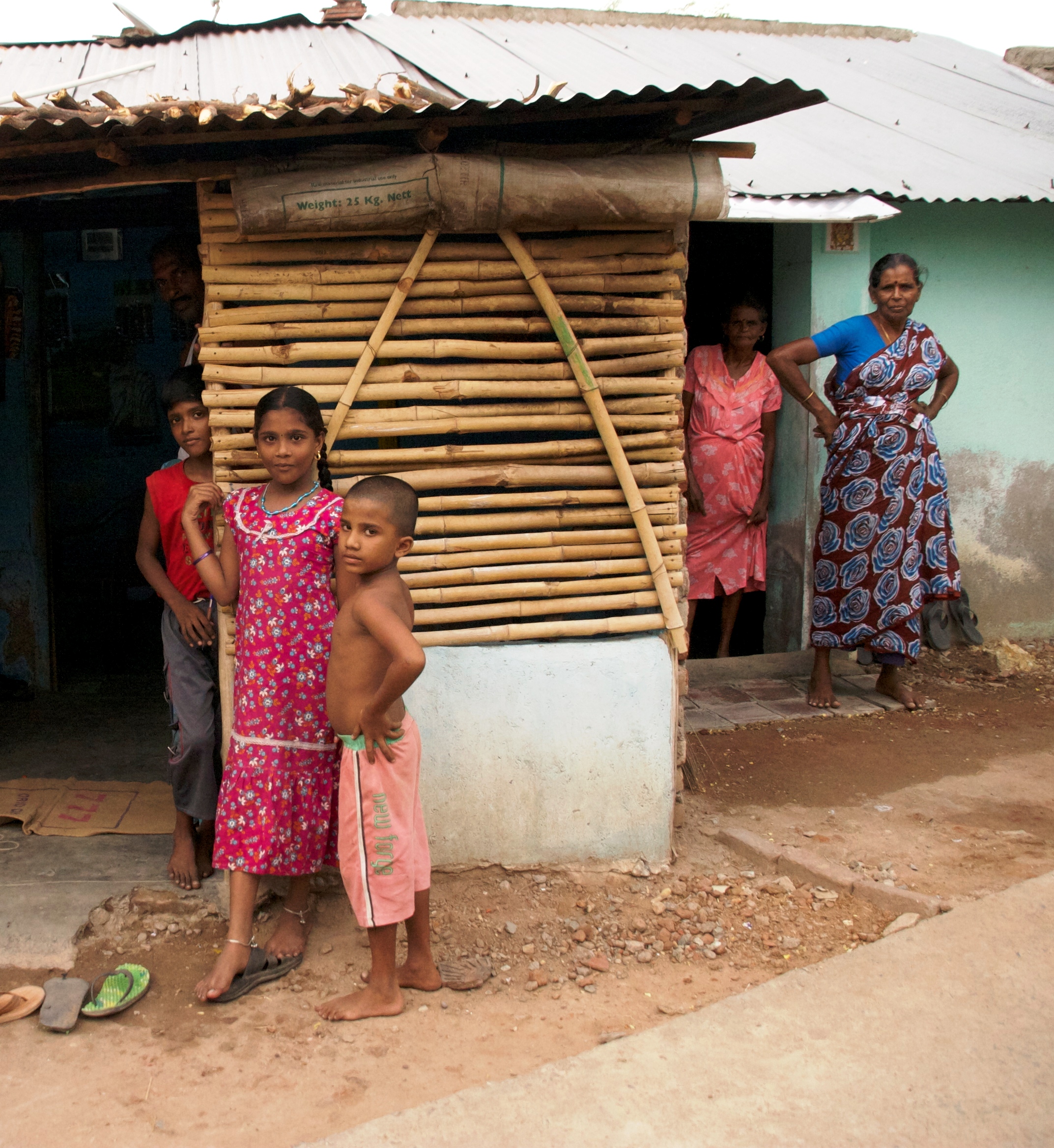 A group of Tamil refugees outside their shelter at a camp in Tamil Nadu ...