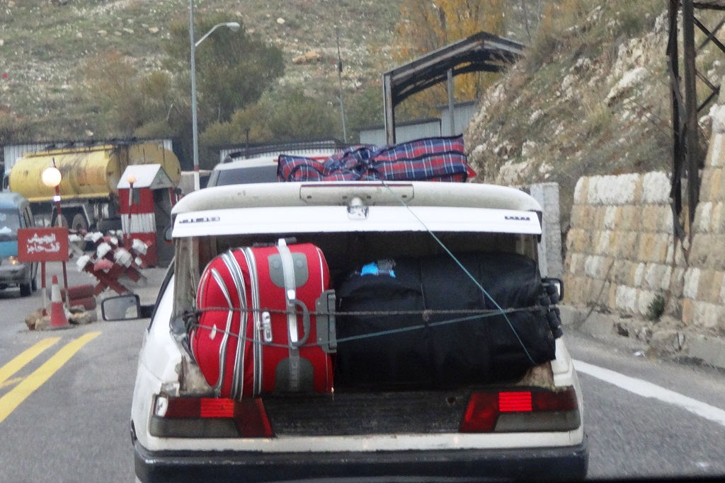 A car with a Syrian license plate crosses the border from Syria to ...