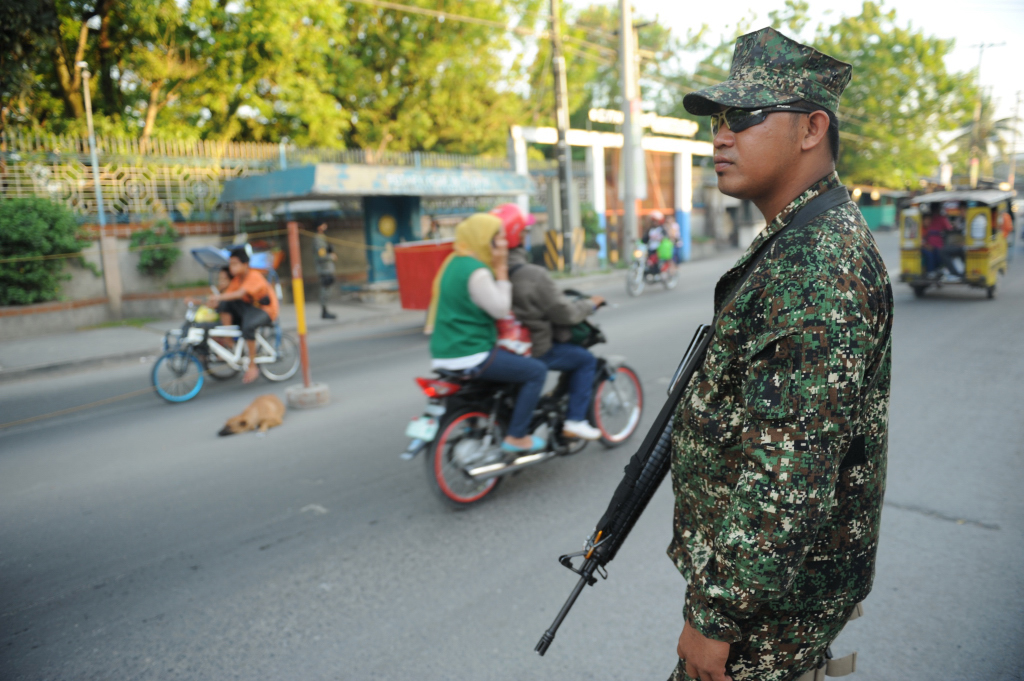 A member of the Armed Forces of the Philippines (AFP) at a checkpoint ...